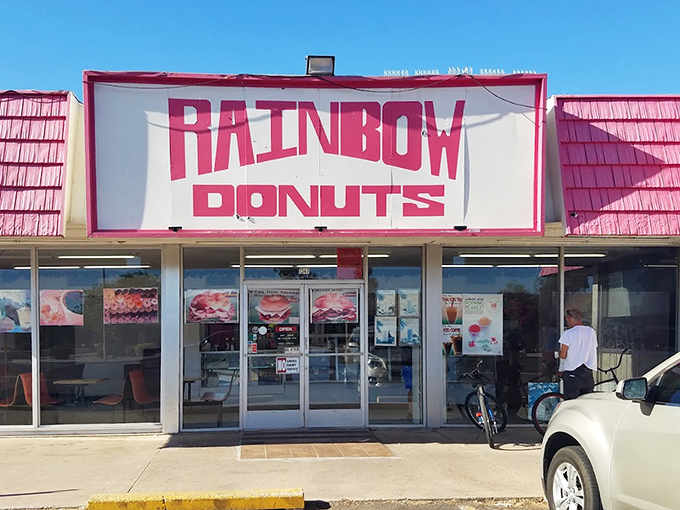 Rainbow Donuts' pink roof stands out like a beacon of sweetness. This Phoenix classic proves sometimes the old ways are still the best.
