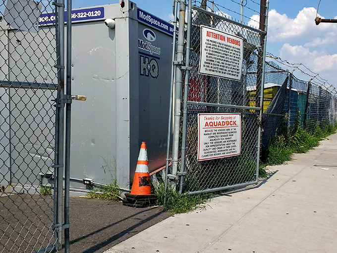 Chain-link fencing surrounds this industrial market space where practical shopping happens without pretense or fancy decorations.