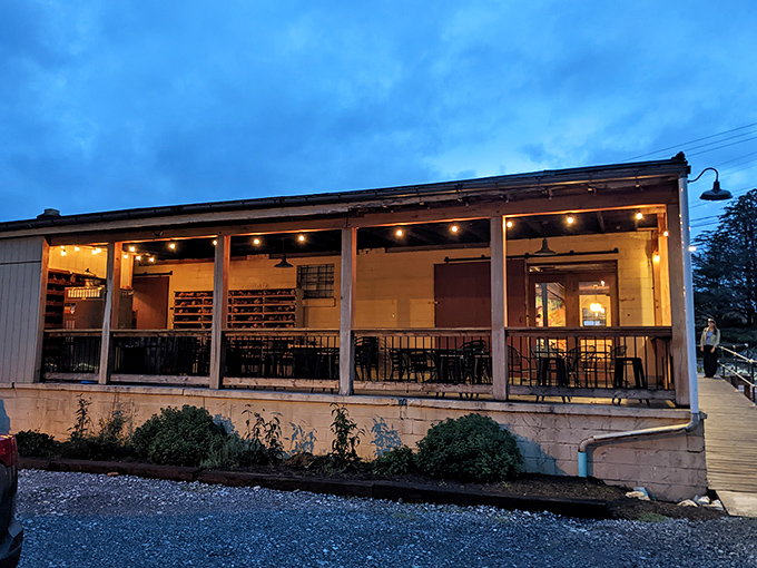 As twilight descends, this riverside restaurant's warm glow becomes a beacon for hungry travelers and locals alike.