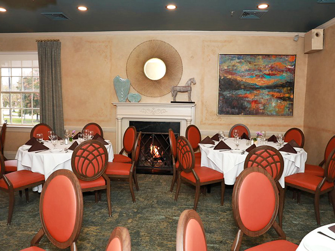 Coral chairs pop against cream walls in this dining room where fireplaces and fine art remind you that dinner can indeed be theater.