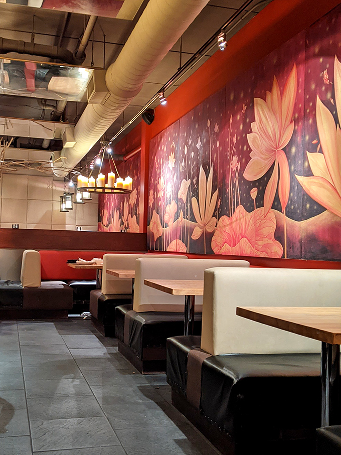 Warm wood tones and dramatic lotus murals create the perfect backdrop for the food drama about to unfold on your plate.