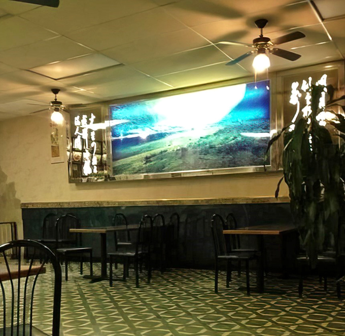 The dining room's serene landscape screen offers a momentary escape to distant mountains while your taste buds take their own journey.