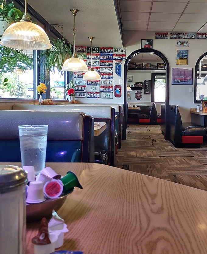 License plates and vintage memorabilia line the walls, creating a museum of Americana where your booth becomes a time machine to simpler days.