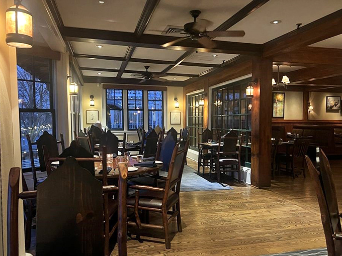 Evening light filters through windows in this dining area, where exposed beams and thoughtful lighting create the perfect backdrop for making memories over meals.