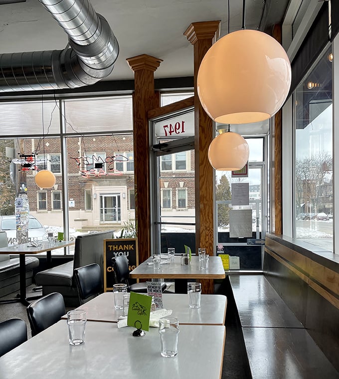 Globe lights and wooden pillars create a warm atmosphere where tables await conversations, confessions, and the clinking of coffee cups.