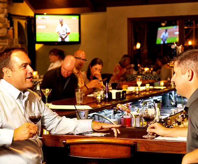 Where wine bottles stand like sentinels guarding liquid treasures. This bar knows the difference between drinking and savoring.