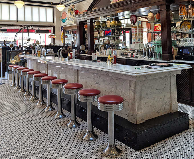 The soda fountain counter with its classic red stools stands ready for ice cream enthusiasts and milkshake aficionados alike.
