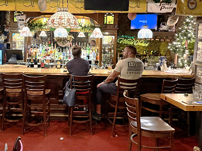The bar glows with amber bottles and Tiffany lamps, a sanctuary where strangers become friends over shared spirits.