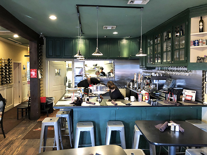 Green cabinets frame the bar area where coffee mugs are filled with the urgency breakfast deserves &ndash; caffeine is serious business here.