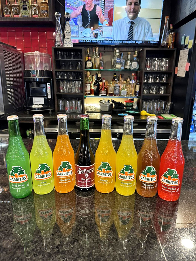 Mexican sodas lined up like a liquid rainbow. These aren't just beverages&mdash;they're childhood memories in glass bottles.