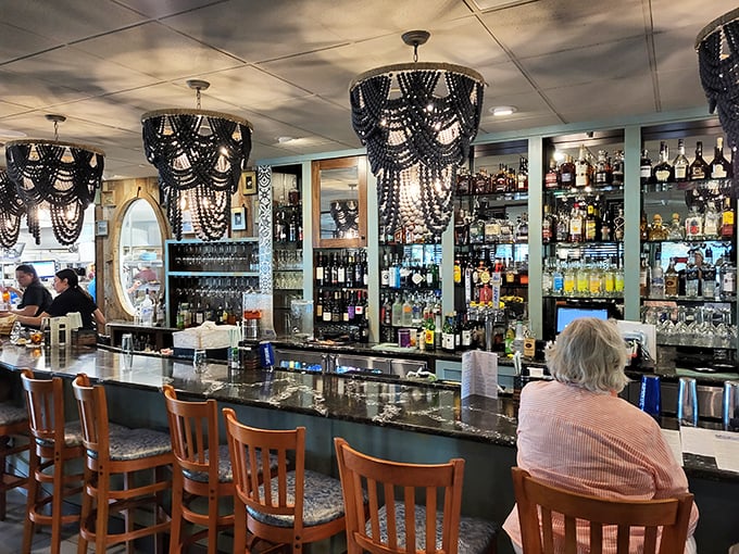 A bar that belongs in a design magazine, with chandeliers that whisper "order something fancy" while the bottles stand ready for adventure.