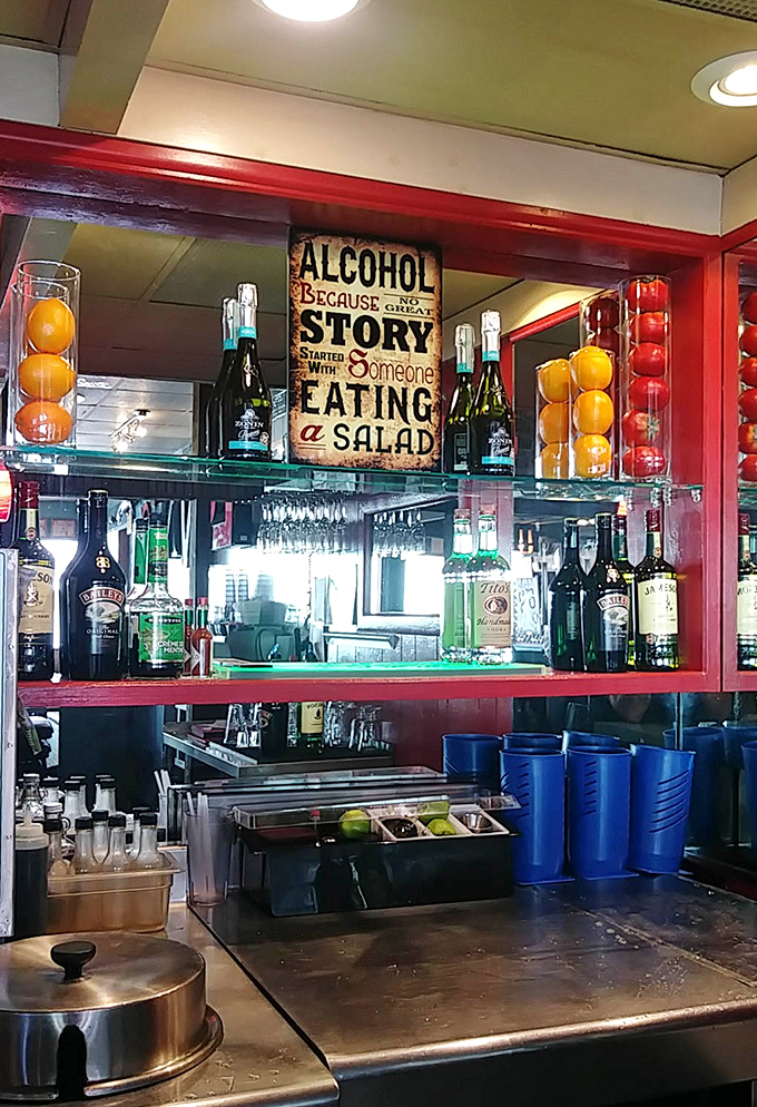Even the bar area maintains that classic diner charm, with a sign that perfectly captures the establishment's philosophy on salad consumption.