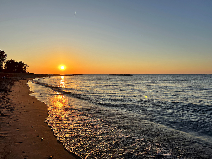 Golden hour transforms the beach into liquid amber, the kind of sunset that makes you forgive Lake Erie for winter.