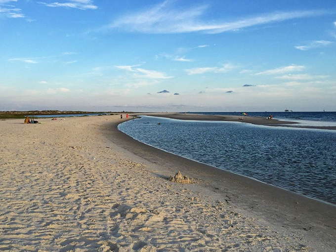That magical moment when the beach curves just so. Dauphin Island's western end creates natural pools where land, sky, and sea negotiate their boundaries.