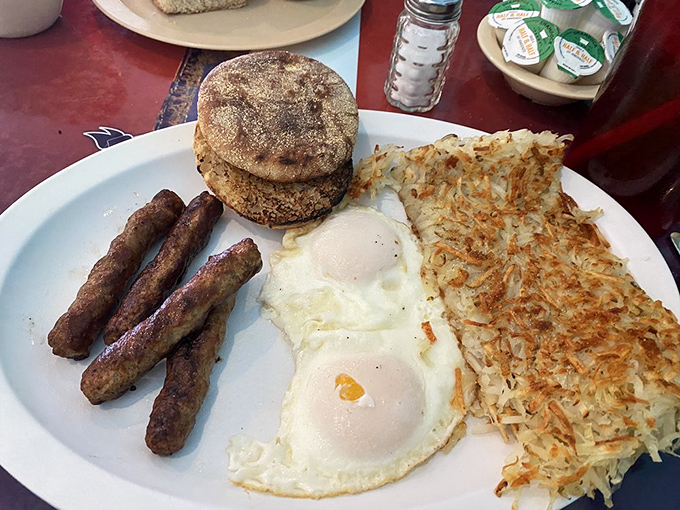 The breakfast holy trinity: perfectly cooked eggs, sausage links with just the right snap, and English muffins waiting for their butter bath.