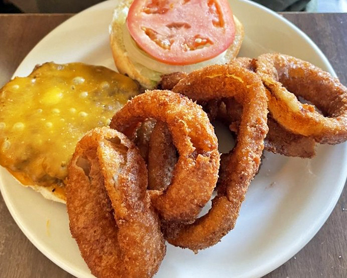 Golden onion rings that shatter with each bite alongside a burger that's been perfected over decades &ndash; simplicity at its most delicious.