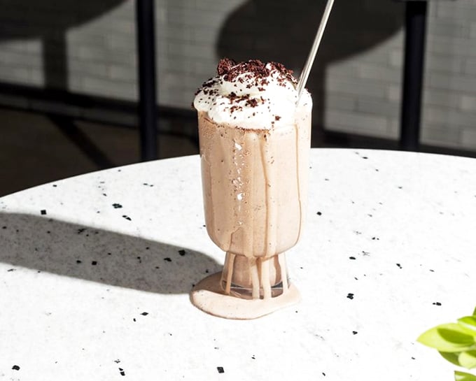 This chocolate shake isn't just a drink, it's dessert architecture&mdash;towering with whipped cream in a glass that screams "special occasion" even on a Tuesday.