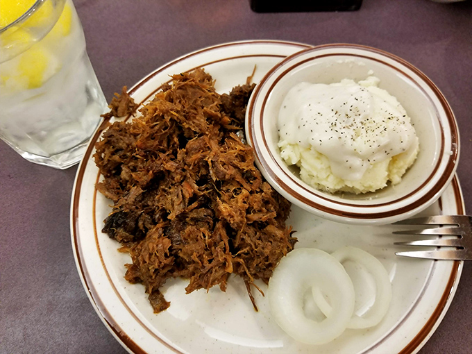 Chopped brisket with that telltale bark, served alongside mashed potatoes and onions&mdash;comfort food that speaks fluent Texan.