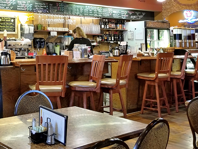 The counter where caffeine dreams come true, with a chalkboard menu of possibilities and wooden stools that have witnessed countless first dates and study sessions.