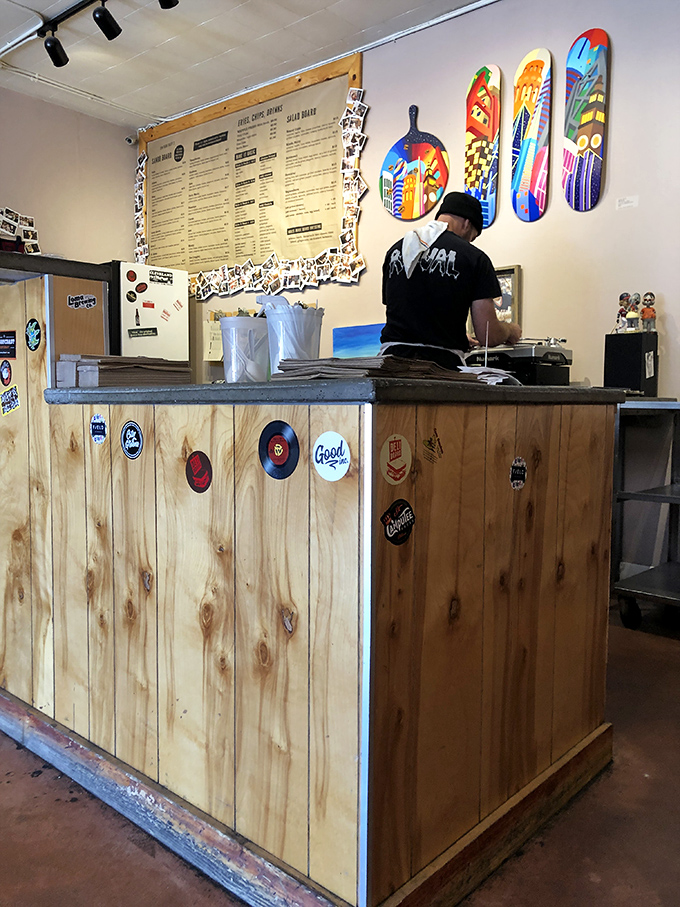 The wooden counter, adorned with stickers and memorabilia, tells stories of sandwich pilgrimages past&mdash;each emblem a badge of deli honor.