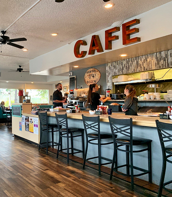 The counter where breakfast magic happens&mdash;complete with vintage "CAFE" sign and the promise of coffee refills as far as the eye can see.