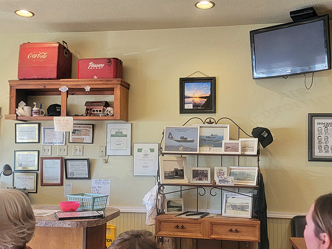 The wall of memories tells stories of community pride, while vintage Coca-Cola coolers stand guard over decades of dining history.