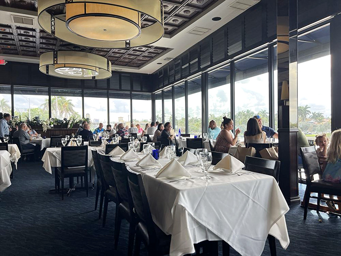 Diners bask in waterfront views through floor-to-ceiling windows, creating that perfect Florida moment where indoor comfort meets outdoor splendor.