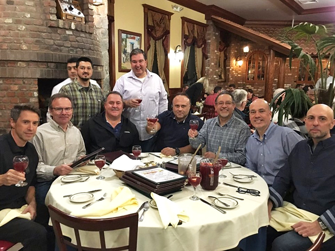The universal language of good food bringing people together. These diners aren't just eating dinner—they're creating memories around that white tablecloth.