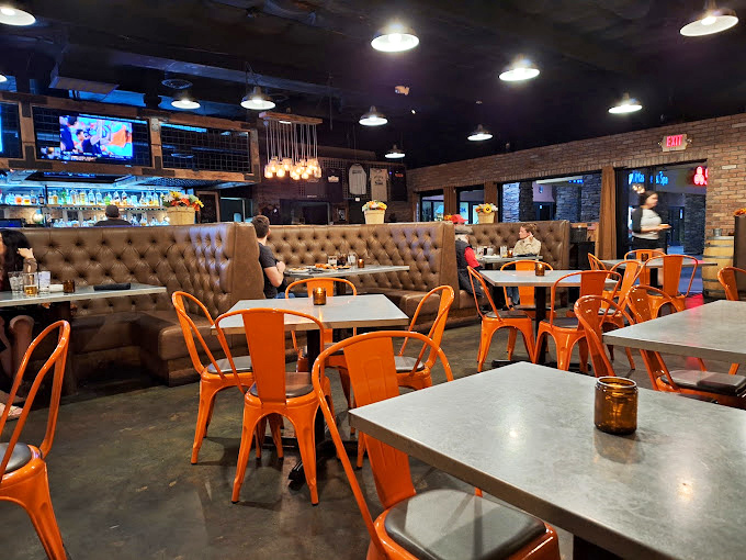 The dining room buzzes with conversation as patrons dive into smoky delights under the warm glow of pendant lights.