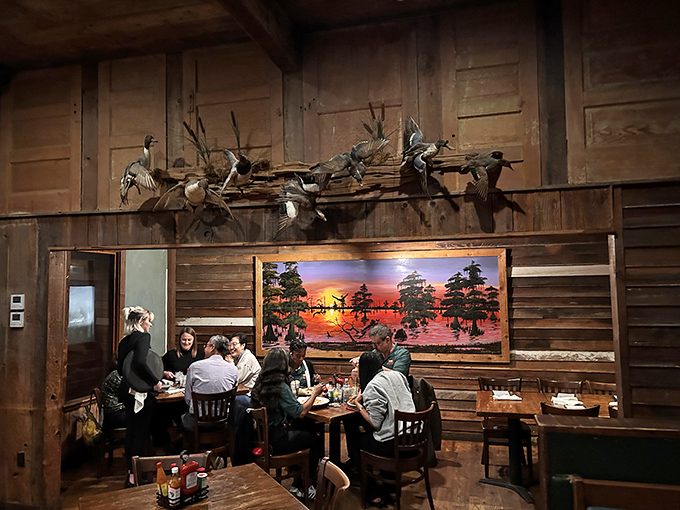 Diners enjoying their meal beneath a stunning bayou sunset painting &ndash; because good Louisiana food deserves equally beautiful surroundings.