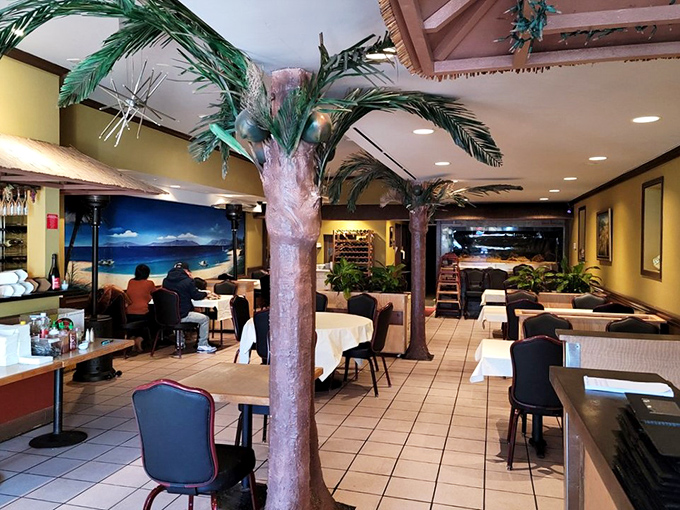 Artificial palm trees create a whimsical oasis in the dining room, where white tablecloths await the beautiful mess of a proper crab feast.