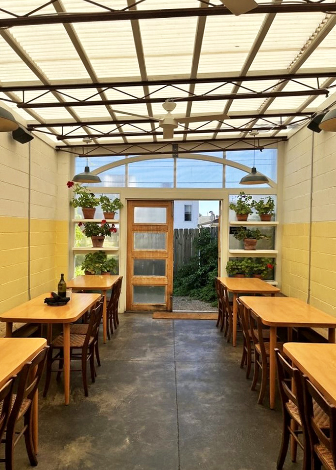 Sunlight streams through the greenhouse-like dining area, where potted plants remind you that great food begins with what grows from the earth.