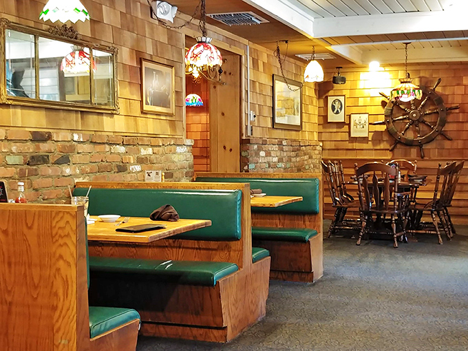 Green booth seating and nautical accents create intimate dining nooks where seafood feasts become memorable family gatherings.