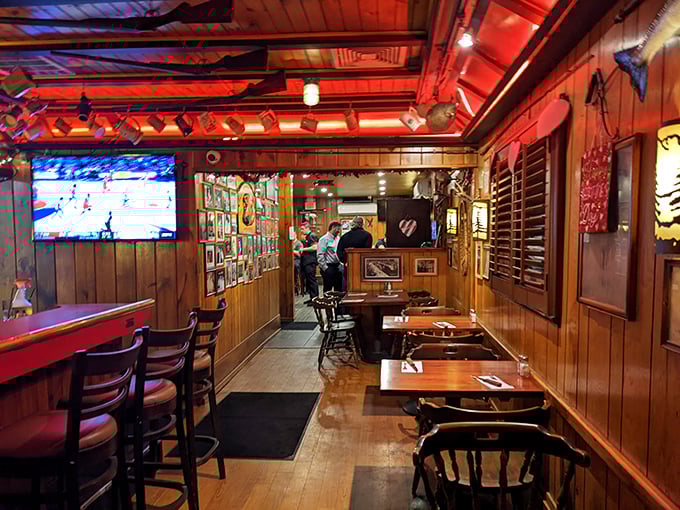 Red lighting casts a warm glow over wooden tables where countless anniversary dinners and birthday celebrations have unfolded.
