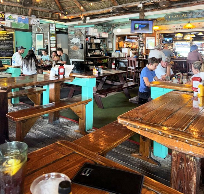 Rustic wooden tables under turquoise accents create the perfect backdrop for seafood feasts where memories outlast the meal itself.