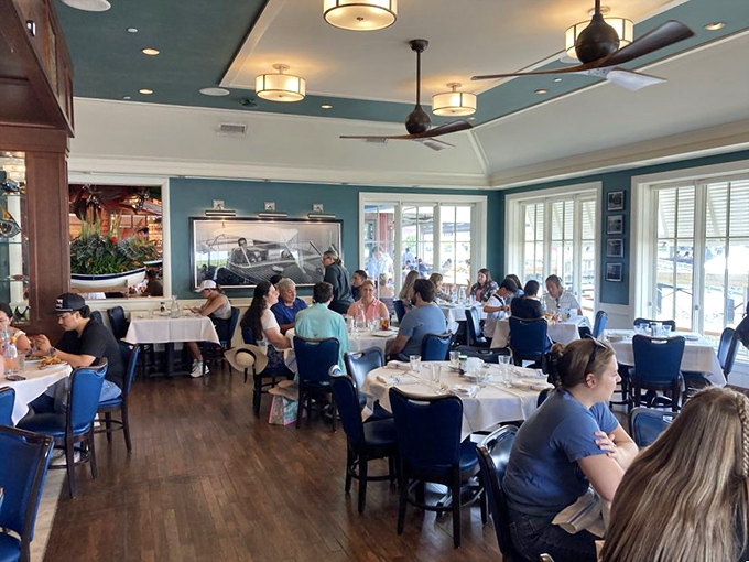 A bustling dining room where nautical blues meet golden woods, and every table feels like you've scored the captain's private quarters.