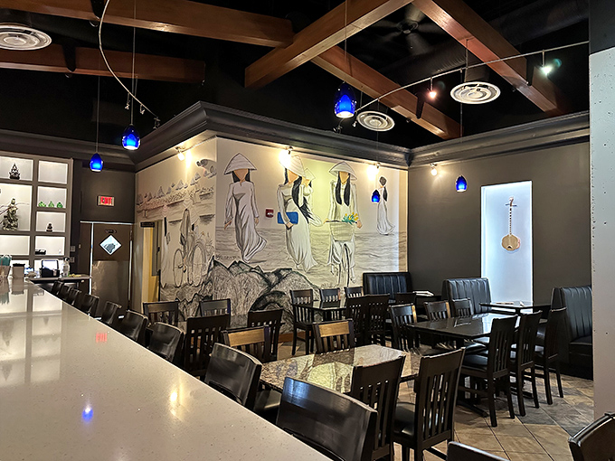 A striking mural of traditional Vietnamese scenes creates an immersive backdrop for your culinary journey through Southeast Asian flavors.