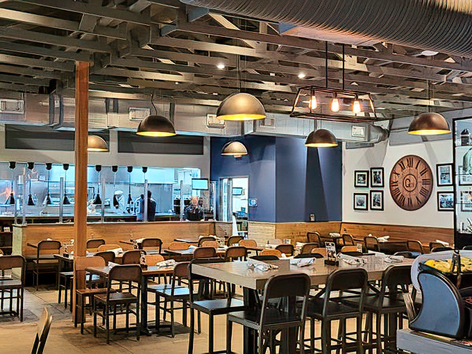 A dining room where industrial meets warmth &ndash; pendant lights casting a glow that makes everyone look like they're in a barbecue commercial.
