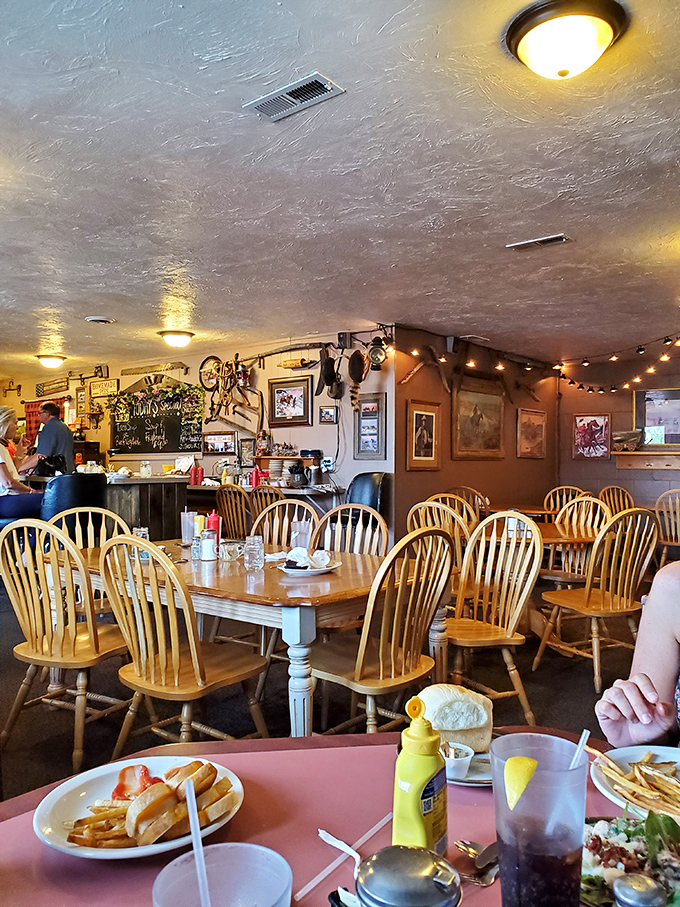 Wooden Windsor chairs gather around tables where memories are made. The string lights add just enough magic to everyday dining.