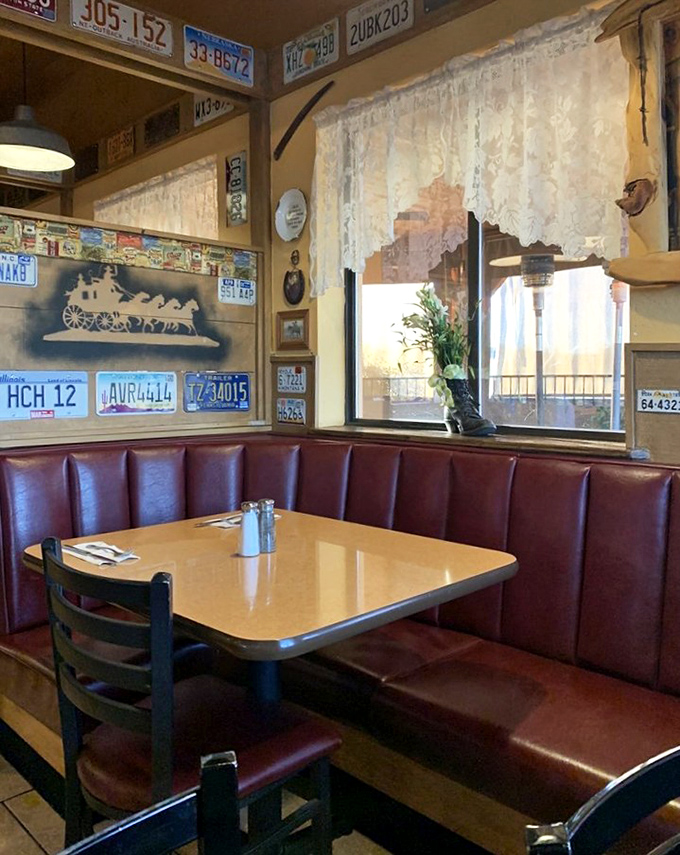 Red vinyl booths beneath license plates create the perfect setting for comfort food conversations. Every booth tells a story&mdash;and holds secrets of meals past.