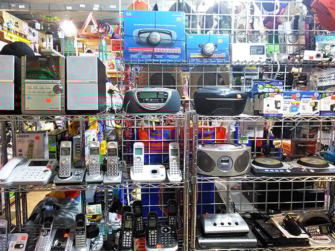 Technology's timeline displayed on metal shelves. From boomboxes to cordless phones, it's like walking through a Best Buy circa 1995.
