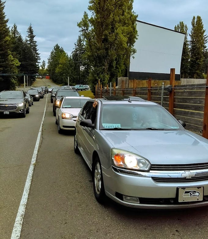 The anticipation builds as cars line up, each vehicle a private viewing room waiting to claim its patch of cinema history.