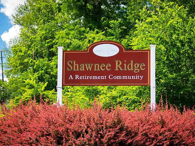 The welcome sign that feels like a warm handshake. Vibrant landscaping frames the entrance to a community that values both beauty and belonging.