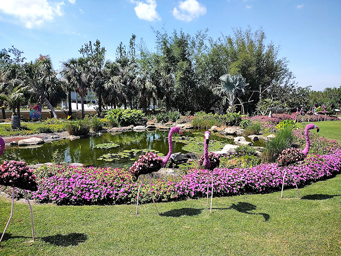 Pink flamingo topiaries surround a picture-perfect pond, creating Florida kitsch elevated to legitimate garden artistry.
