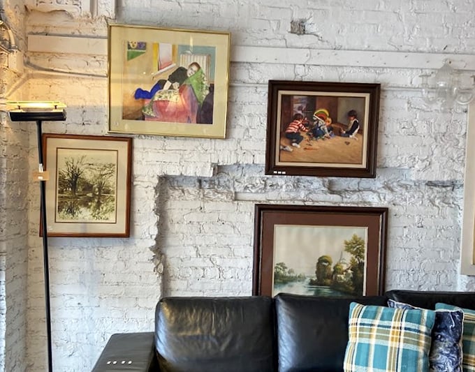 Framed artwork transforms white brick walls into an impromptu gallery &ndash; someone's discarded landscape might become your living room centerpiece.