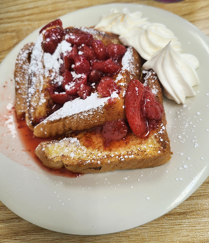 French toast that's dressed for success with berries, powdered sugar, and whipped cream—the breakfast equivalent of wearing a tuxedo to the mailbox.