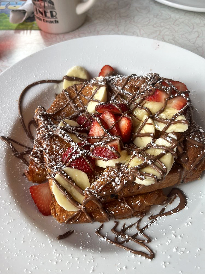 French toast that's dressed for success with strawberries, bananas, and chocolate drizzle &ndash; breakfast masquerading as dessert, and nobody's complaining.
