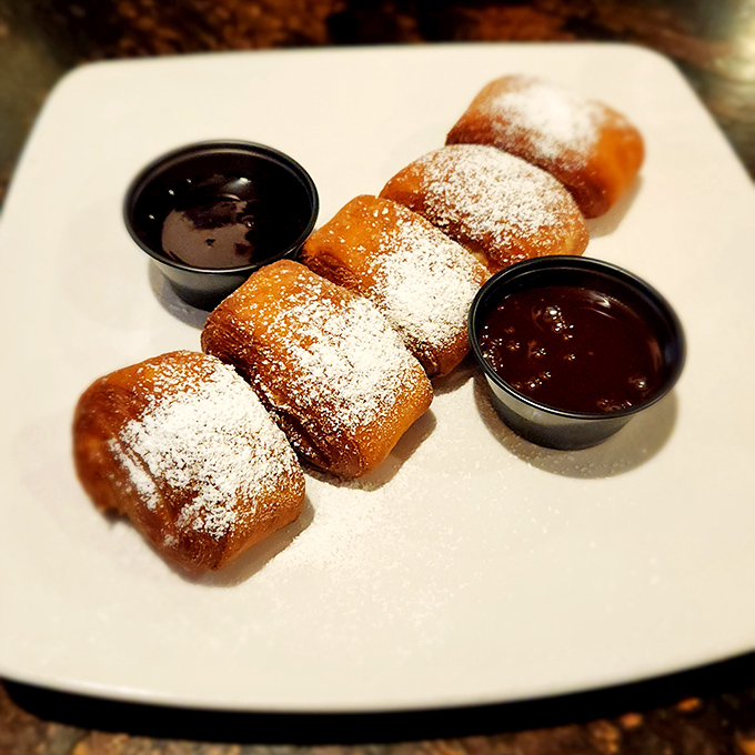 Fried cheesecake bites dusted with powdered sugar—because sometimes dessert should be portable, shareable, and utterly irresistible.