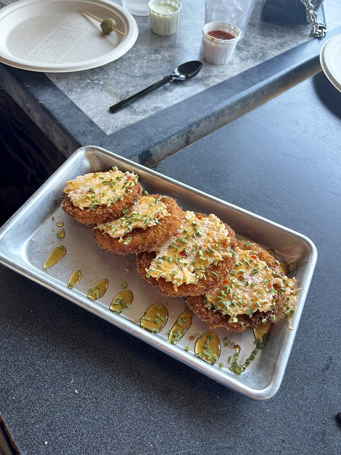 Fried green tomatoes glistening with a drizzle of something magical. Southern ingenuity transformed unripe fruit into a dish worth crossing state lines for.