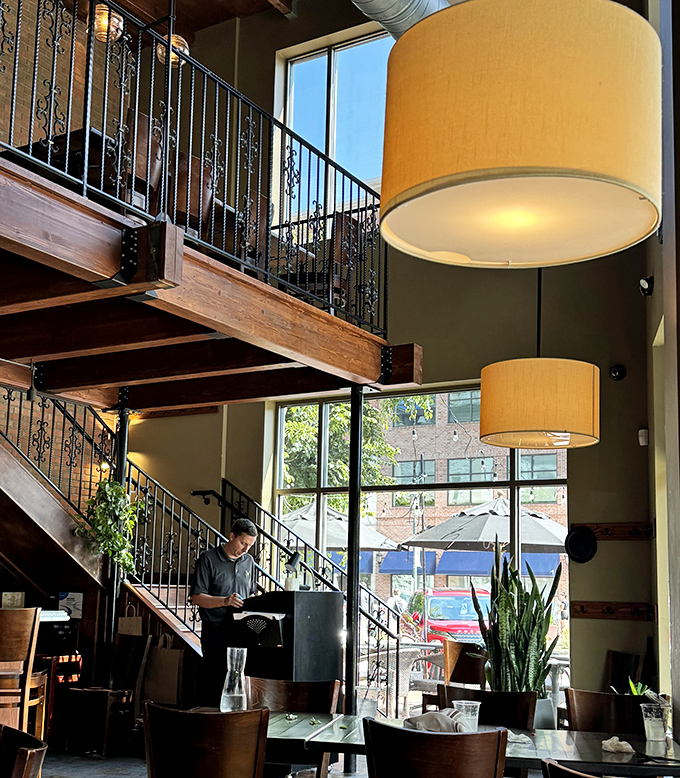 Two-story dining with dramatic flair. Those pendant lamps aren't just lighting the space&mdash;they're setting the stage for culinary theater.